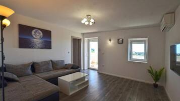 Uma sala de estar moderna com um sofá, uma mesa de centro e uma pintura da lua na parede.