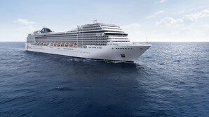 Um grande navio de cruzeiro com vários decks e varandas, navegando no oceano.