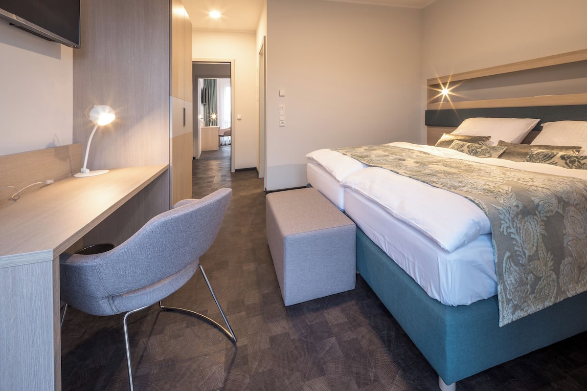 Quarto moderno com uma cama, uma escrivaninha e uma cadeira.