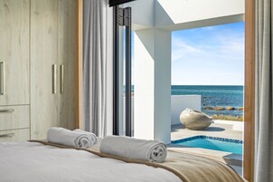 Quarto com vista para o mar, uma piscina e uma grande tigela de pedra.