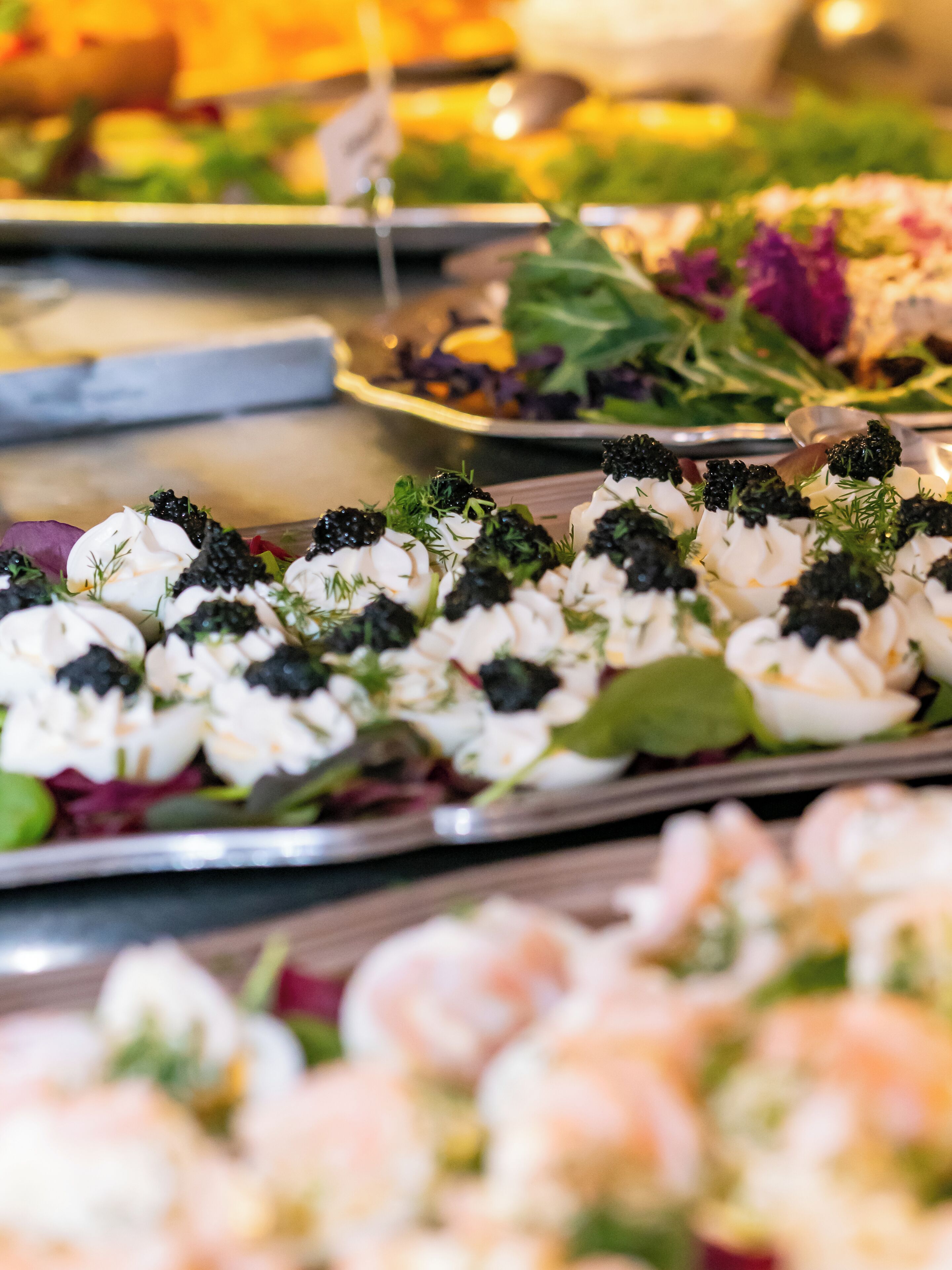 Buffet com diversos pratos, incluindo frutos do mar e saladas.