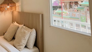 Quarto com uma janela ampla com vista para um edifício tradicional e arquitetura ornamentada.