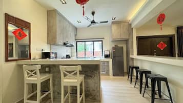 Cozinha moderna com ilha central, banquetas e ventilador de teto.
