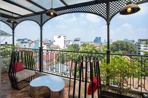 Uma varanda com vista para o horizonte urbano, incluindo edifícios e um rio.