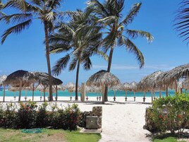 Perto da praia, praia de areia branca, espreguiçadeiras 