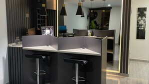 Uma cozinha moderna com ilha central, banquetas, luminárias pendentes e vista para a sala de jantar.