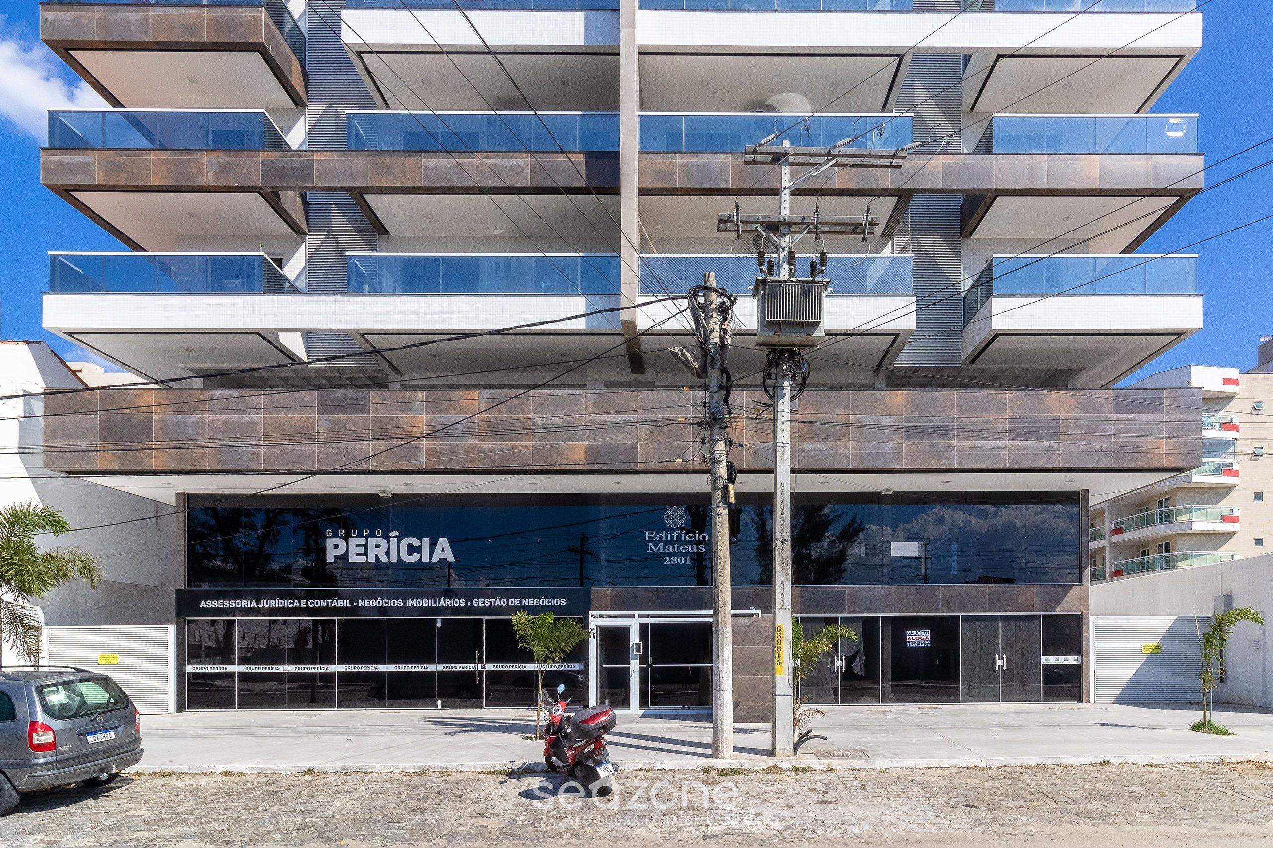 Um edifício moderno com várias varandas e uma fachada de vidro extensa.