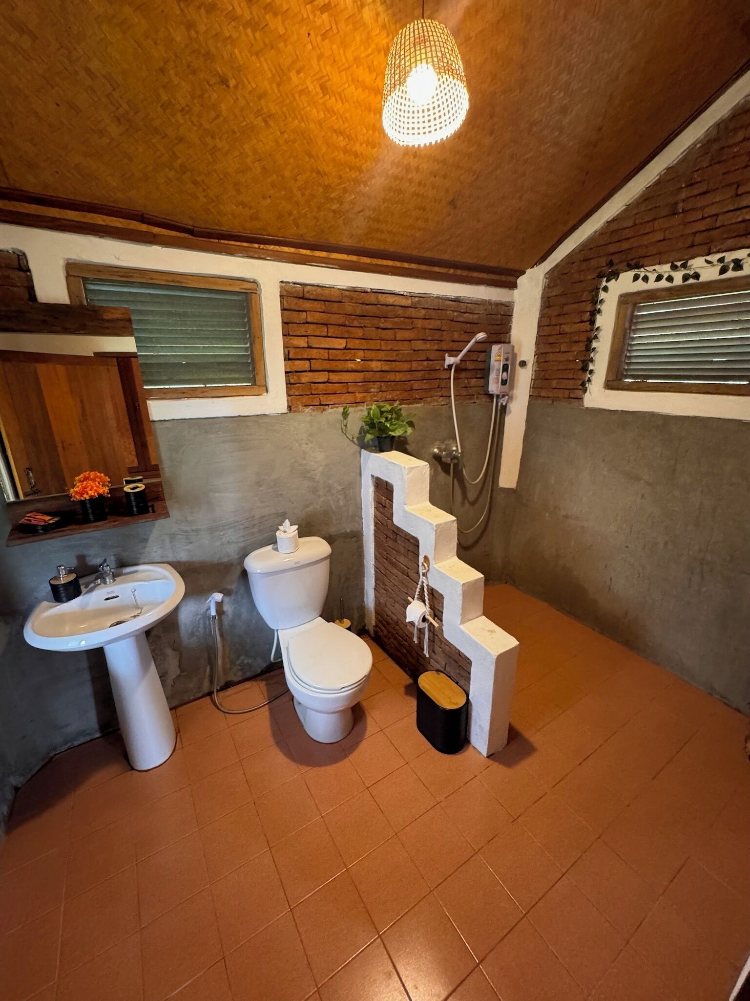 Uma casa de banho compacta com lavatório, sanita e chuveiro.