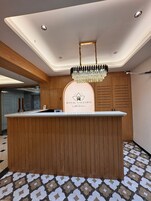 Uma receção com candelabro, painéis de madeira e o logótipo da Royal Galleria.