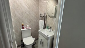Uma casa de banho moderna com sanita, lavatório e espelho.