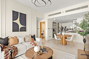 Uma sala de estar moderna com sofá, mesa de centro e área de refeições.
