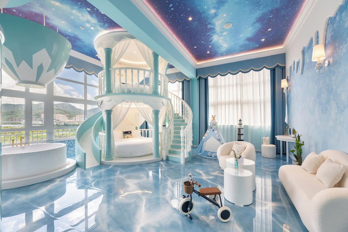 Um quarto luxuoso com teto estrelado, escada em espiral, uma grande janela com vista, um sofá branco e uma pequena mesa com abajur.