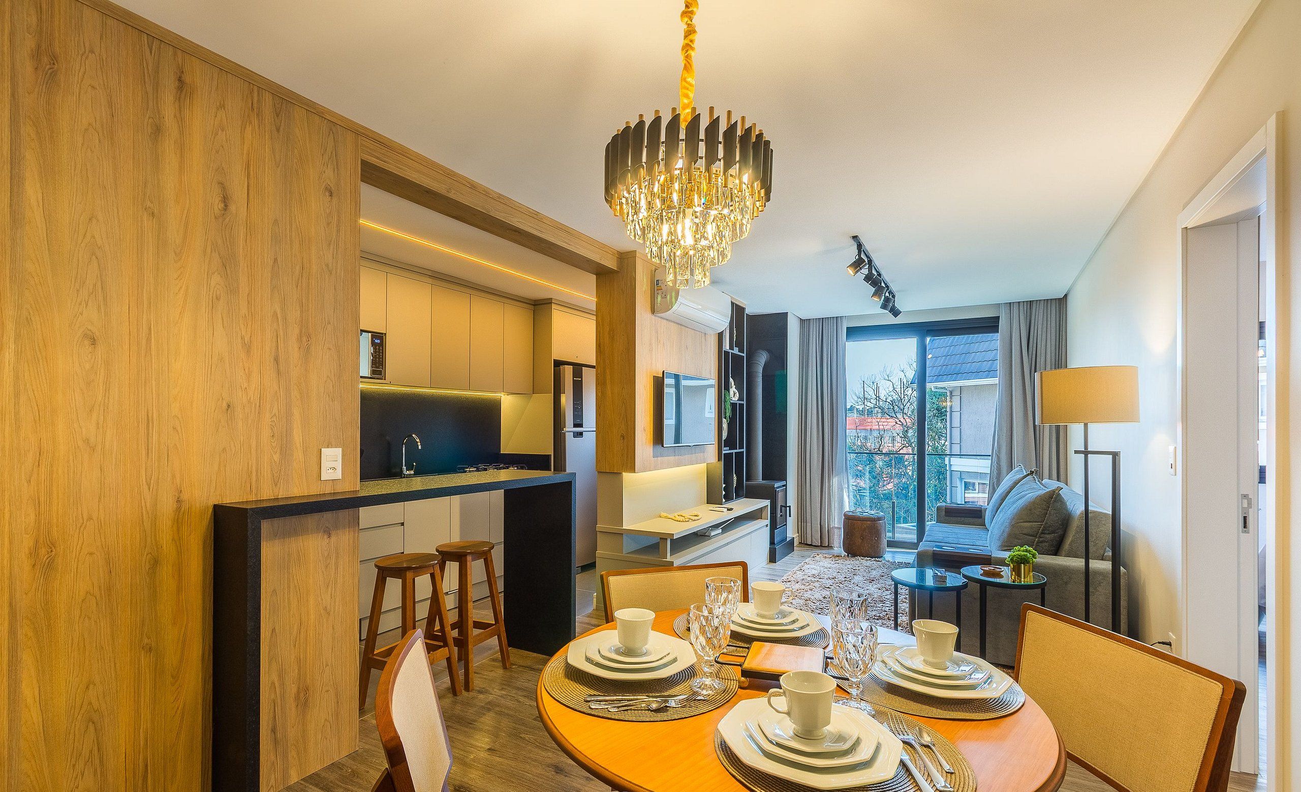 Quarto de hotel moderno com área de jantar, cozinha e sala de estar com vista.