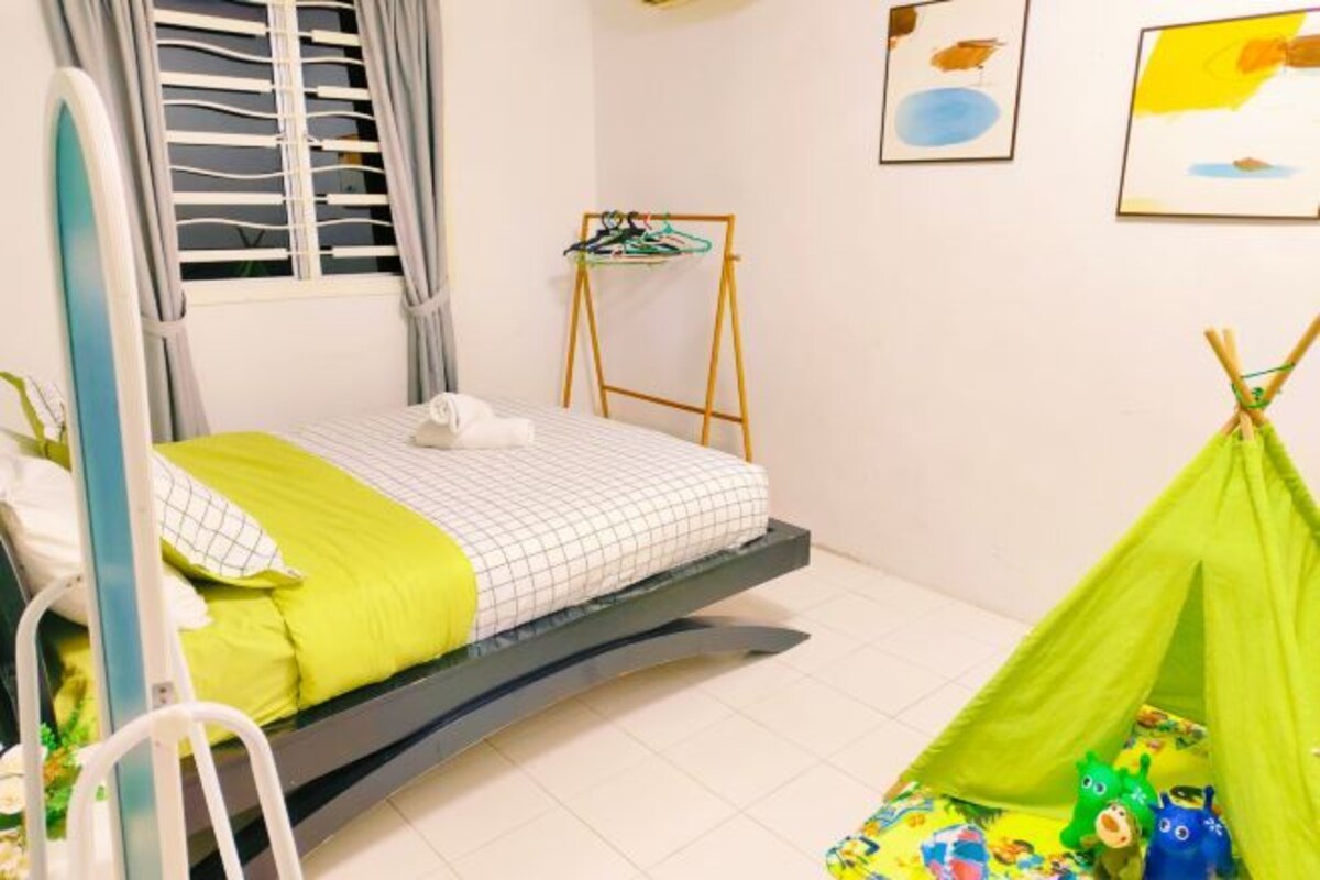 Um quarto com uma cama, uma janela com persianas, um cabideiro e uma estrutura verde semelhante a uma tenda.