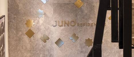 Uma parede com um padrão geométrico e o texto "JUNO RESIDENS".