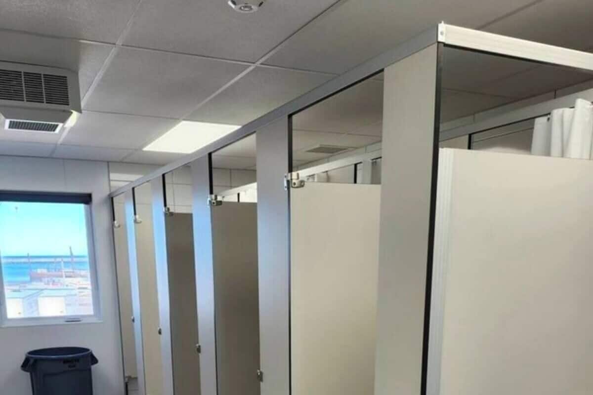 Fileira de quartos individuais com vista para o mar através de uma janela.