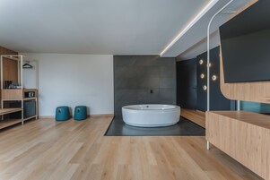 Um banheiro moderno com uma banheira independente, armários de madeira e design minimalista.