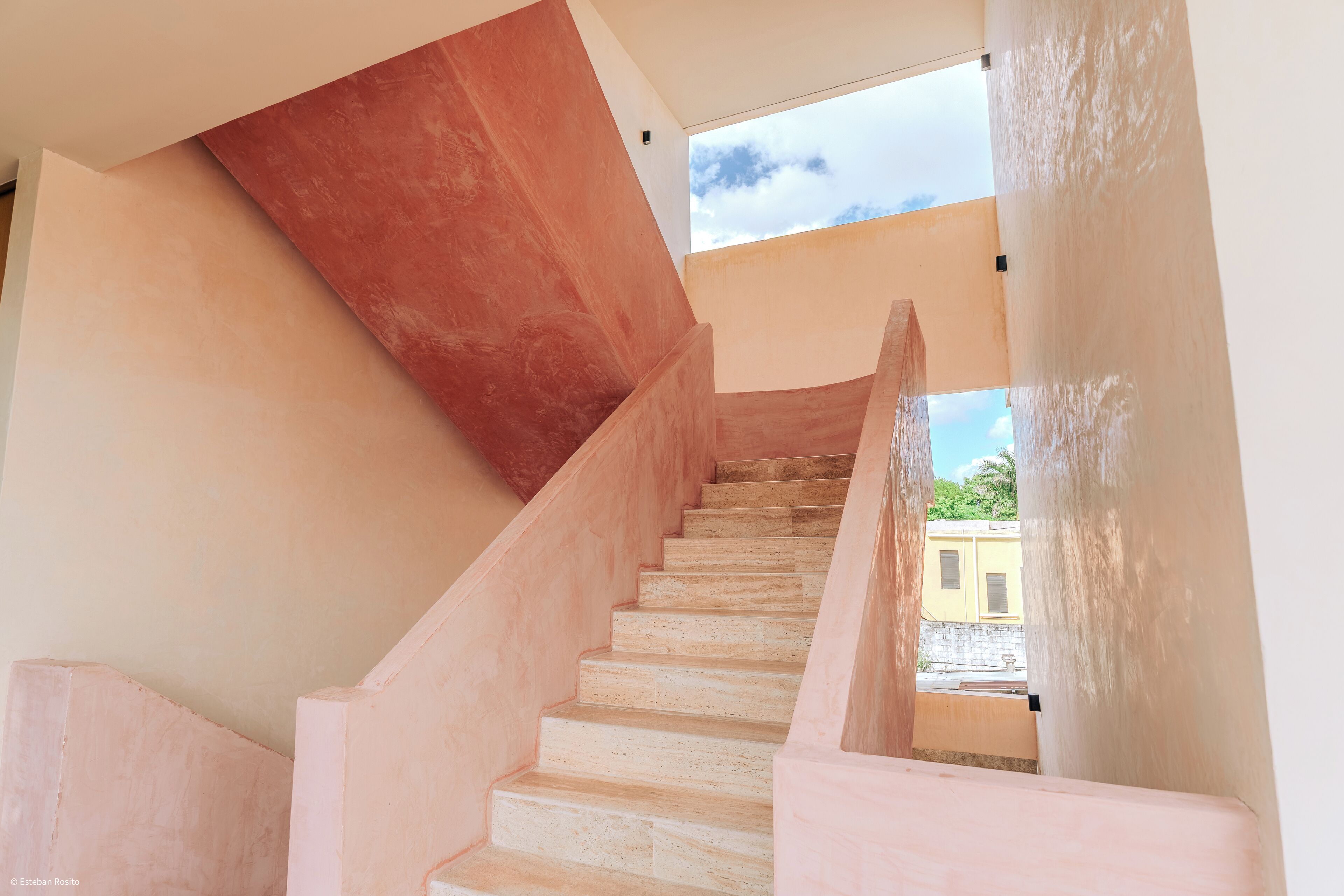 Escadaria com design moderno que leva a uma área externa.