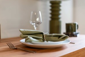 Um prato com uma toalha de mesa dobrada e um garfo sobre uma mesa de madeira.