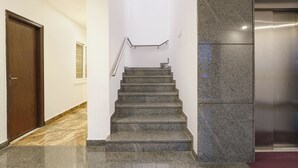 Uma escada com corrimão que leva a um elevador.