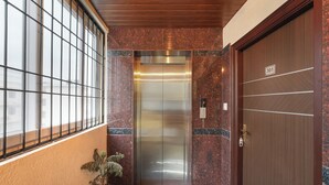 Um elevador com interior metálico e porta de madeira com placa de identificação.