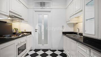 Apartamento, 3 quartos, Vista para a cidade | Cozinha privada | Um frigorífico/congelador grande, um micro-ondas, uma placa de cozinha