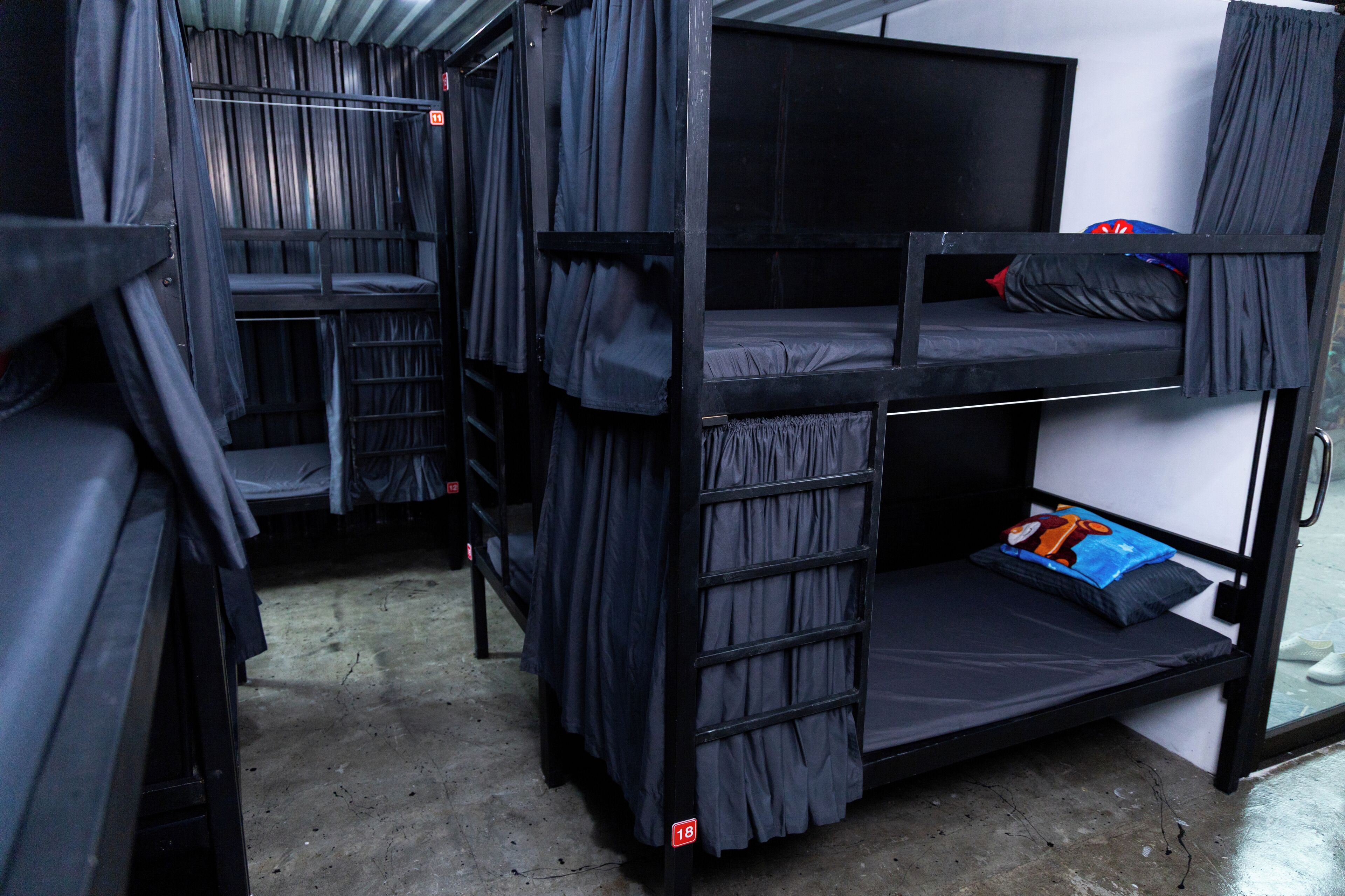 Quarto com beliche, cortinas, colchão e travesseiro.