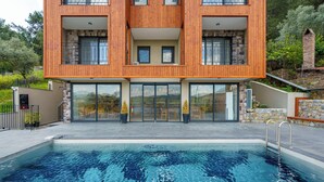 Um edifício moderno de dois andares com piscina em frente.