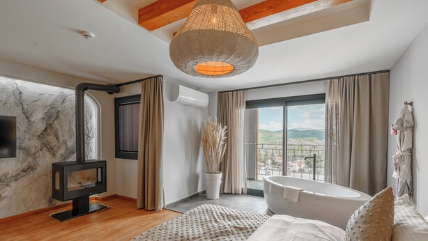 Quarto moderno com uma grande janela, lareira, banheira e vista da cidade.