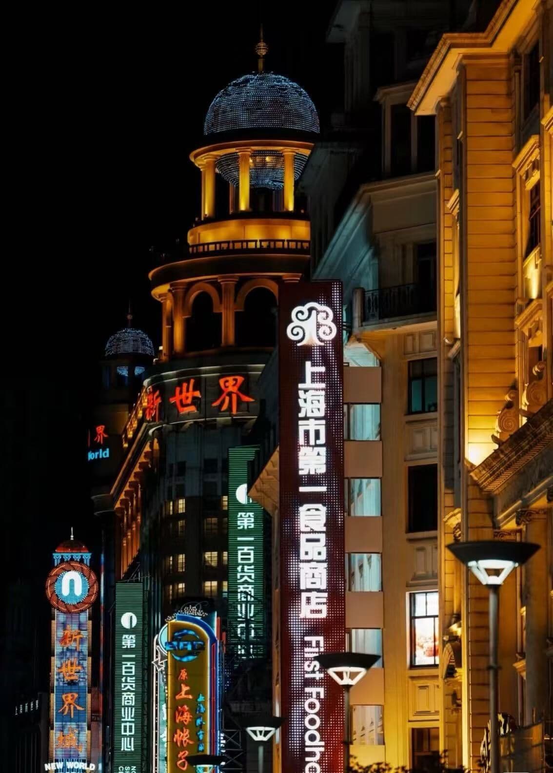 Um edifício com sinalização iluminada, incluindo uma placa para uma loja de alimentos e outra para um centro de negócios.