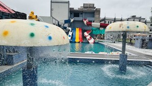 Piscina com toboáguas e uma estátua.