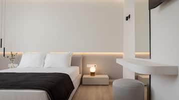 Quarto moderno com cama, mesa de cabeceira, abajur e um banquinho.