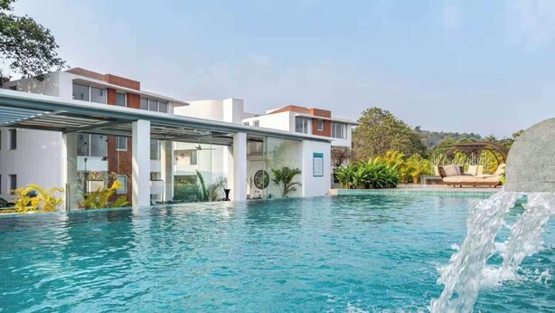 Um hotel moderno com piscina, área de estar ao ar livre e uma cascata.