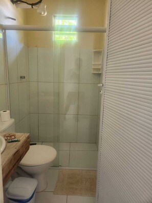 Chuveiro, toalhas de banho, sabonete, papel higiênico