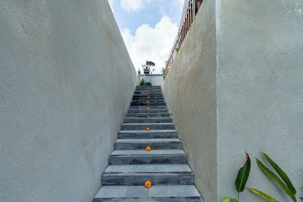 Uma escadaria estreita com padrão quadriculado que leva a um edifício.