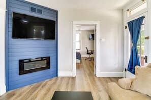 Uma sala de estar moderna com uma parede azul, uma lareira e um sofá.