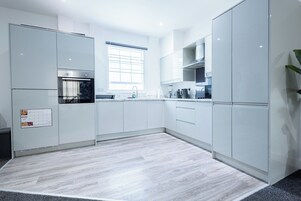 Um frigorífico, um micro-ondas, um forno, uma placa de cozinha 