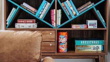 Uma estante de madeira com livros e jogos de tabuleiro.