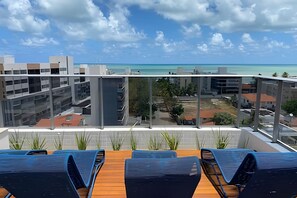 Varanda com vista para um edifício moderno e o oceano.