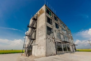 Um edifício de concreto com escadas, janelas amplas e telhado plano.