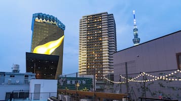 Um edifício moderno com uma estrutura em forma de chama à esquerda, um arranha-céu no centro e uma torre com um pináculo à direita.