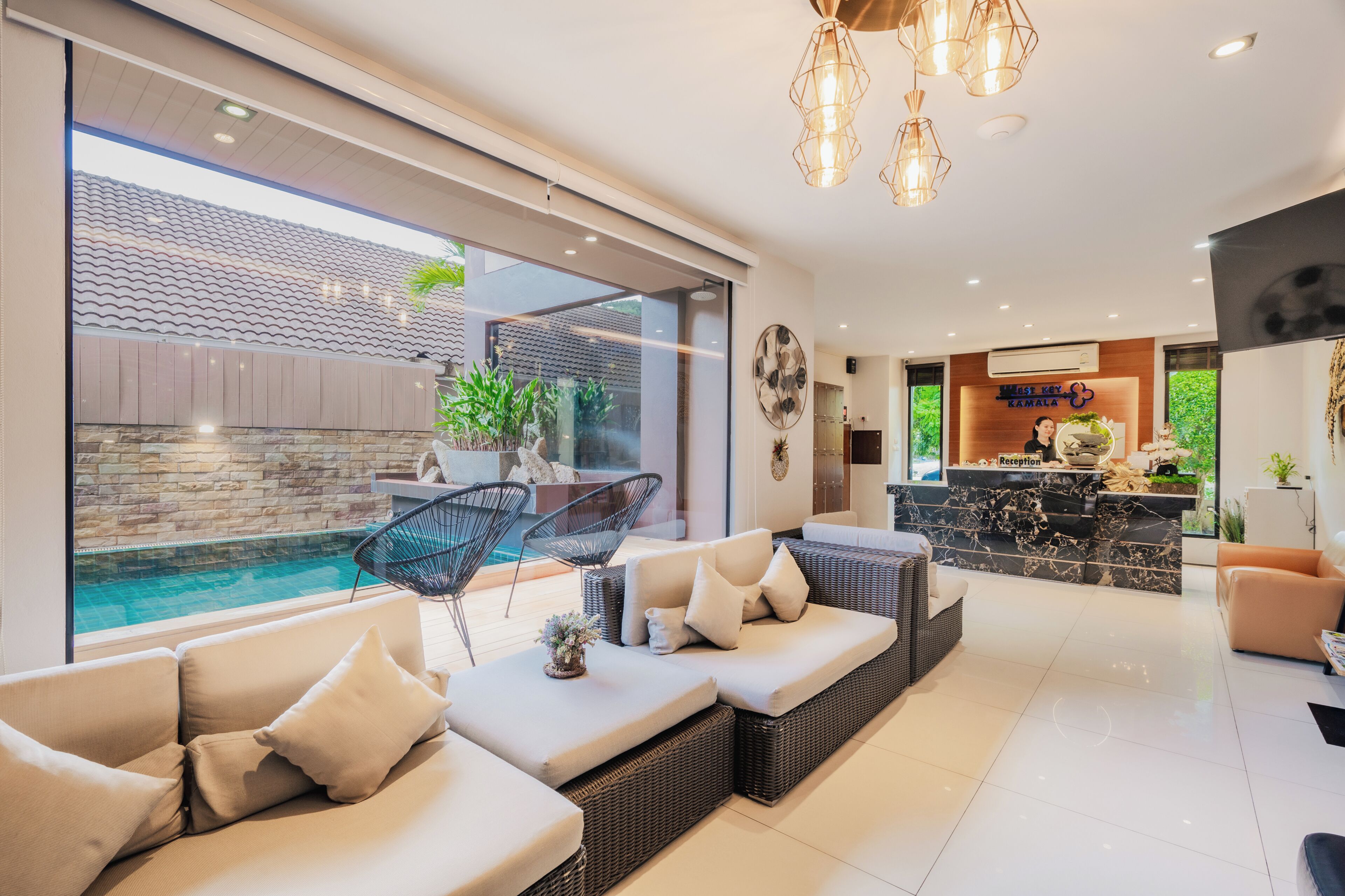 Interior moderno com piscina, mobiliário de vime e um balcão de recepção.