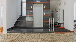Uma escadaria leva a um andar tipo G com design moderno, incluindo corrimão de metal e uma porta com uma placa acima.