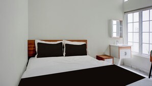 Quarto moderno com uma cama grande, cabeceira de madeira, mesa de cabeceira pequena, pia embutida e janela com vista.