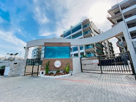 Um edifício moderno com entrada circular, uma janela grande e uma placa indicando a área de recepção.