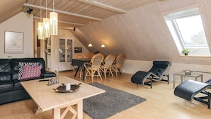Um quarto acolhedor no estilo loft, com área de refeições, um sofá e uma janela com uma planta.