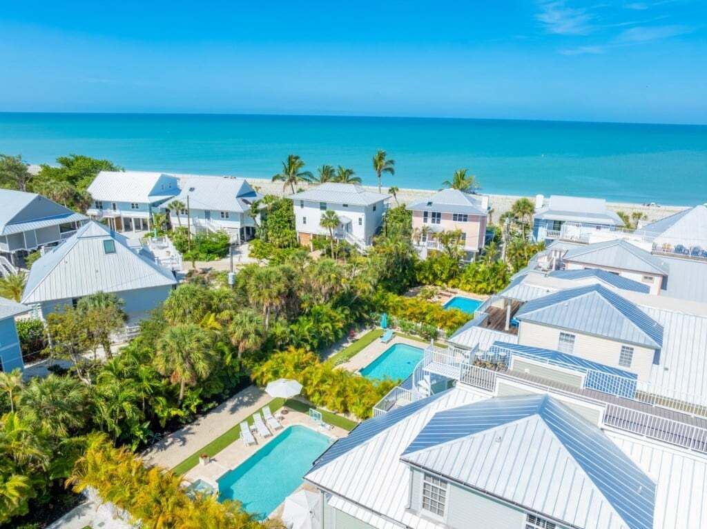 Resort costeiro com vários edifícios, piscina e vista para o oceano.