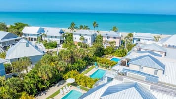 Resort costeiro com vários edifícios, piscina e vista para o oceano.