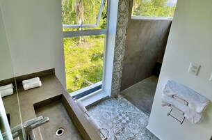 Casa de banho com janela, uma pia e um porta-toalhas.