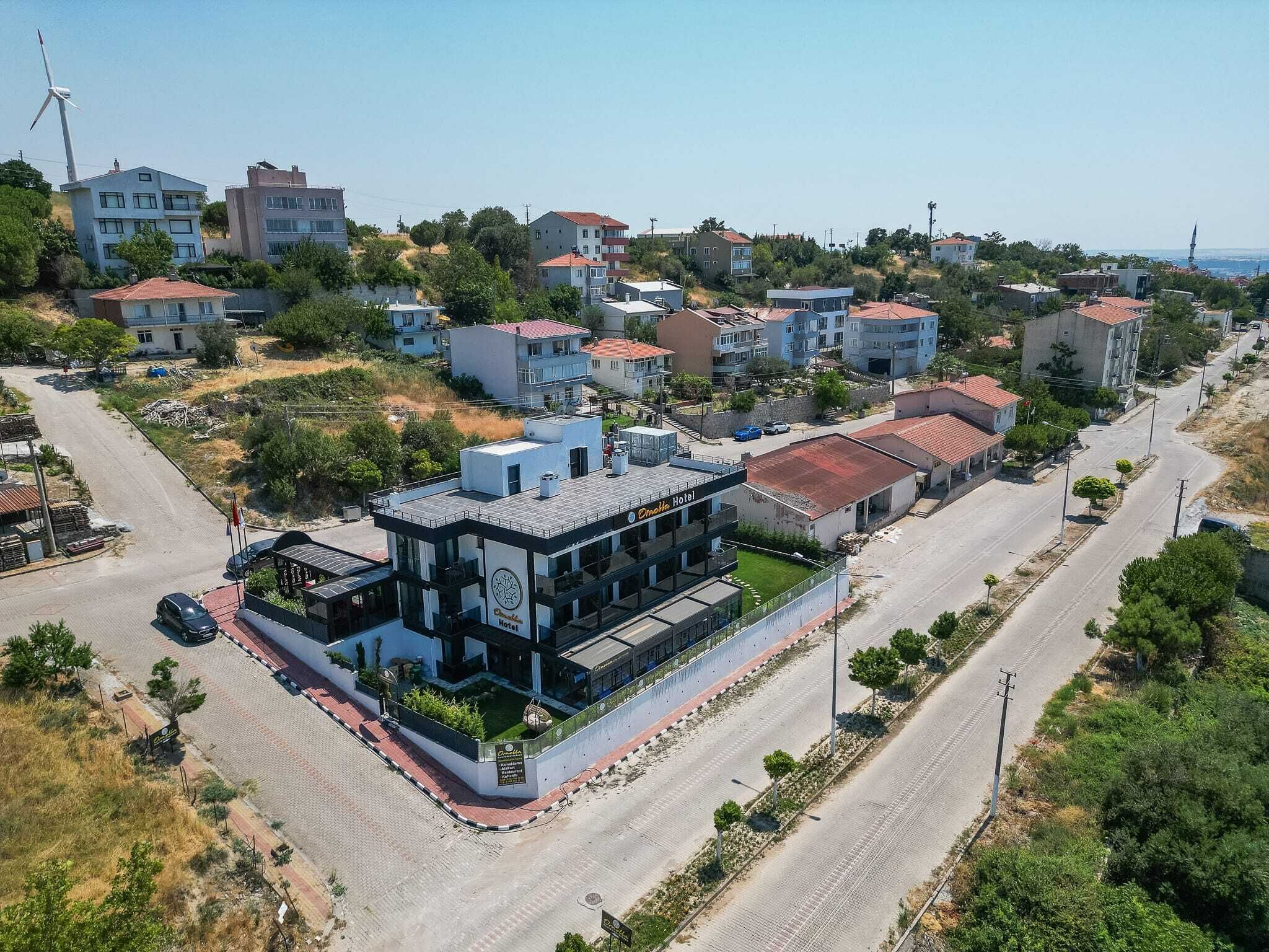 Vista aérea de um hotel com design moderno, situado numa rua rodeada por edifícios residenciais.